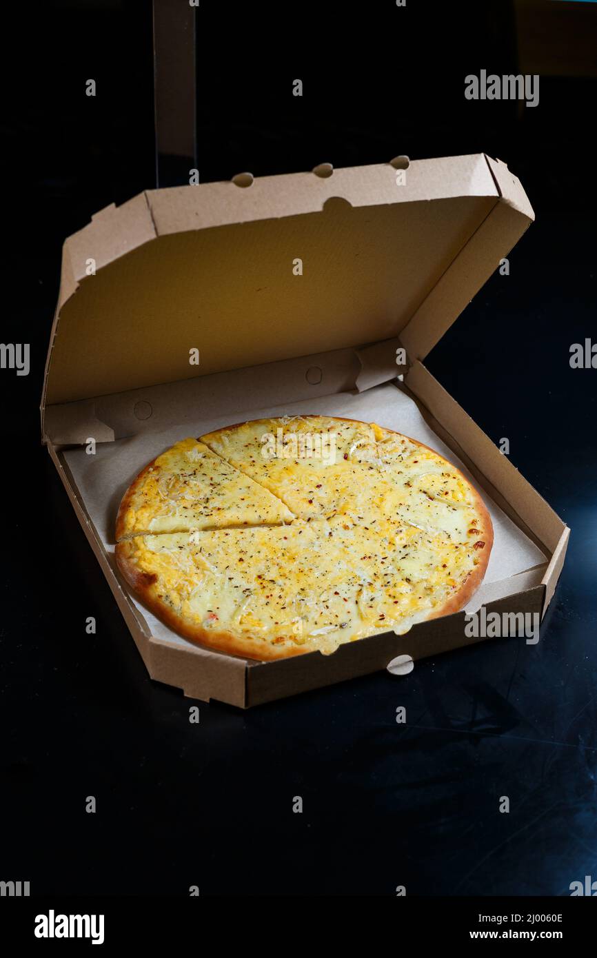 Fresh pizza with cheese in a cardboard craft box, freshly baked pizza ...