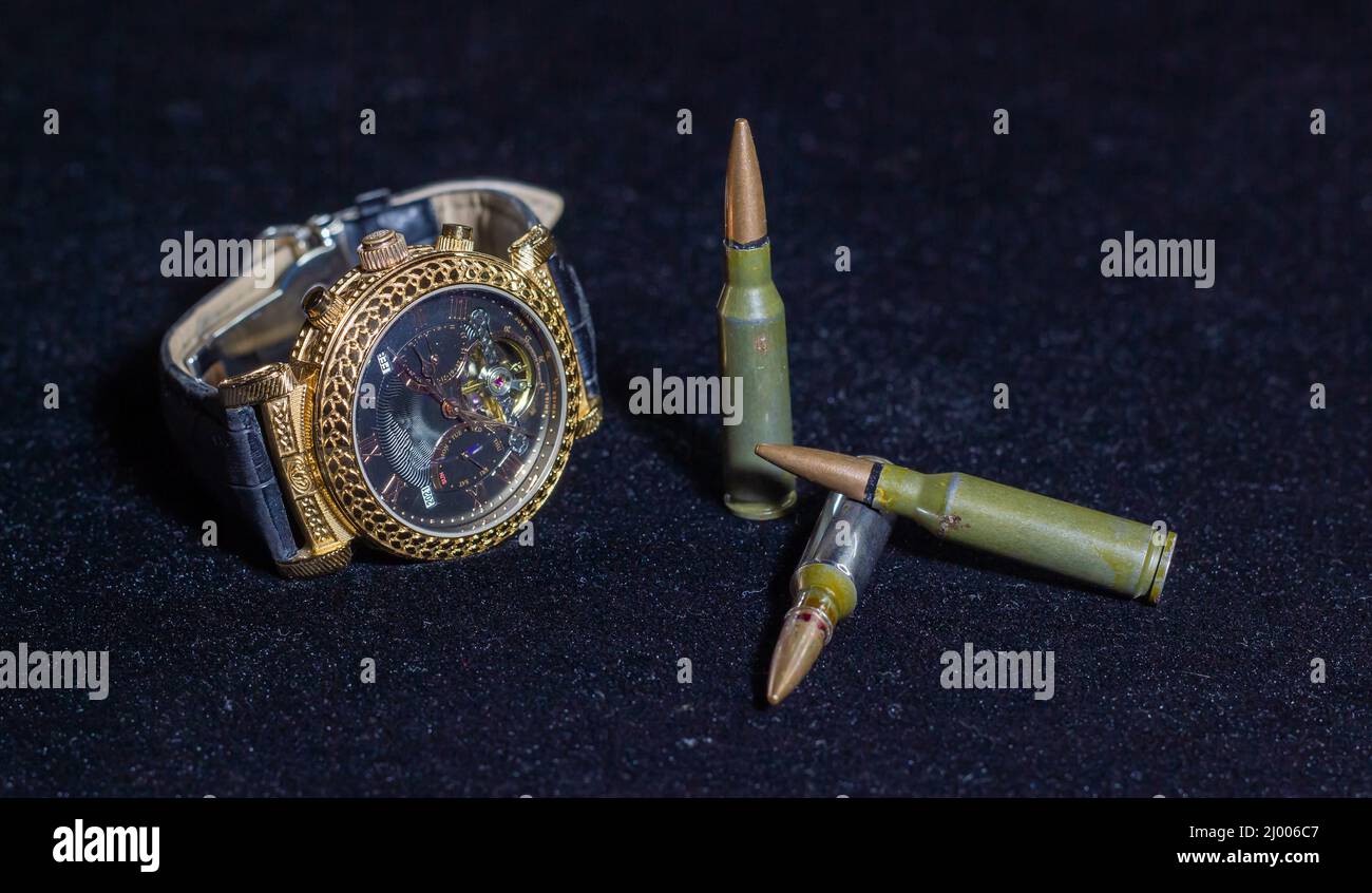 Closeup of a watch near bullets on a blue fabric surface Stock Photo ...