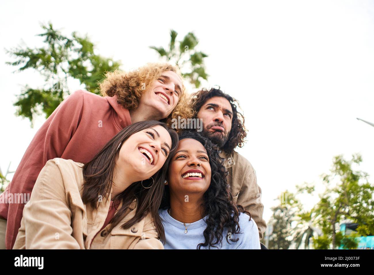 Happy young people embracing and having a fun. Smiling cheerful friends ...