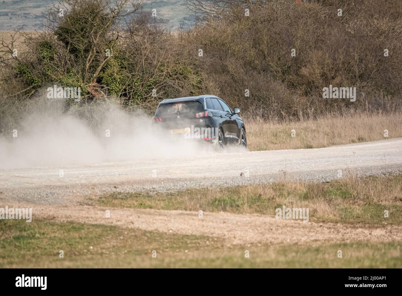 Black Peugeot 5008 GT sport utility vehicle driving along an unmade ...