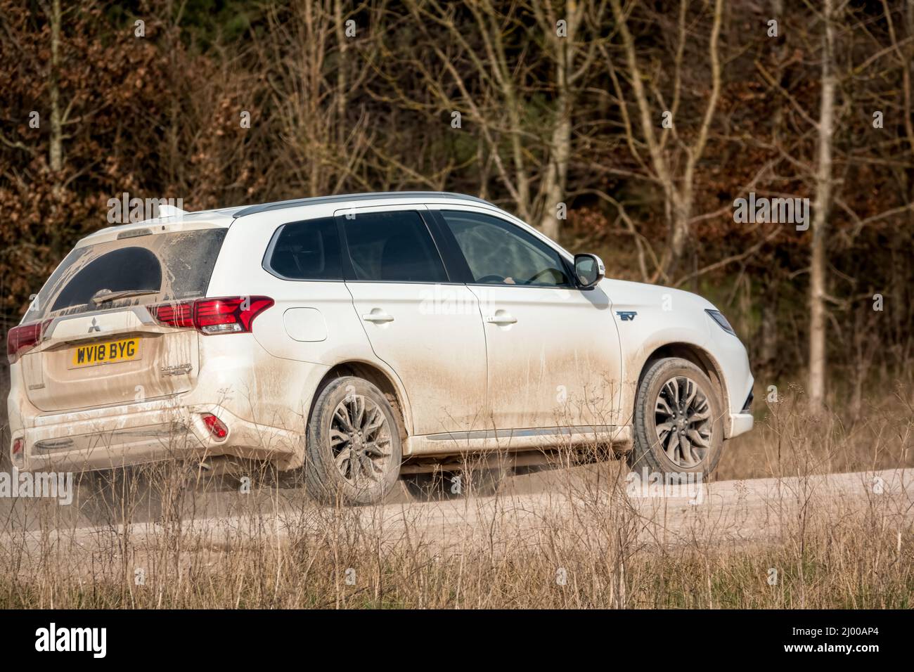White Mitsubishi Outlander PHEV sport utility vehicle driving along an ...