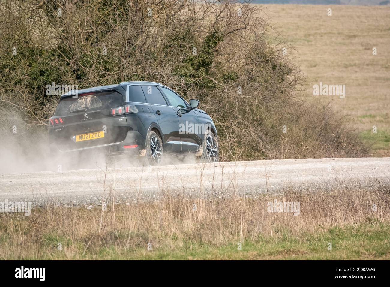 Black Peugeot 5008 GT sport utility vehicle driving along an unmade ...