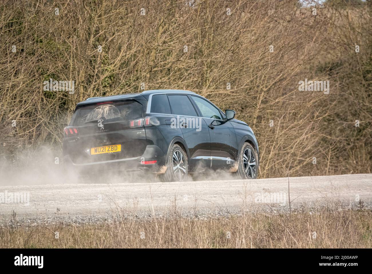 Black Peugeot 5008 GT sport utility vehicle driving along an unmade ...