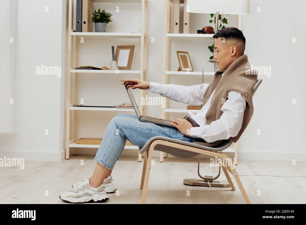 worker on a laptop in a chair in a freelance room Gray background Stock ...