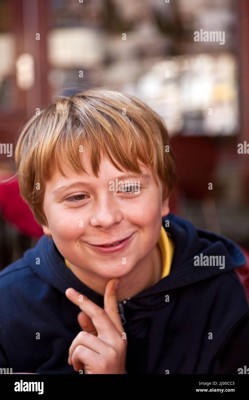 portrait of a handsome smiling boy sitting outside Stock Photo - Alamy