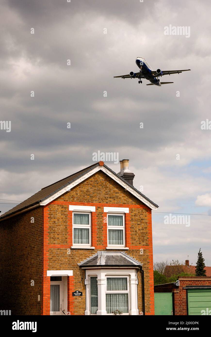 London, England - April 2007: Low flying jet passing overhead a house ...