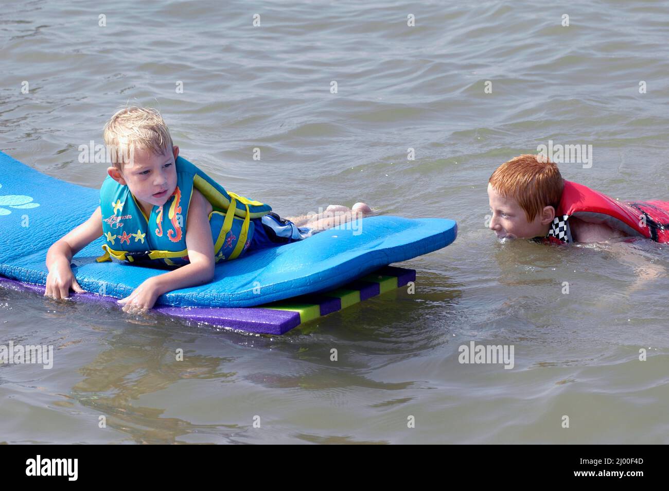 Kids with their inflatable boat at the lake Stock Photo - Alamy