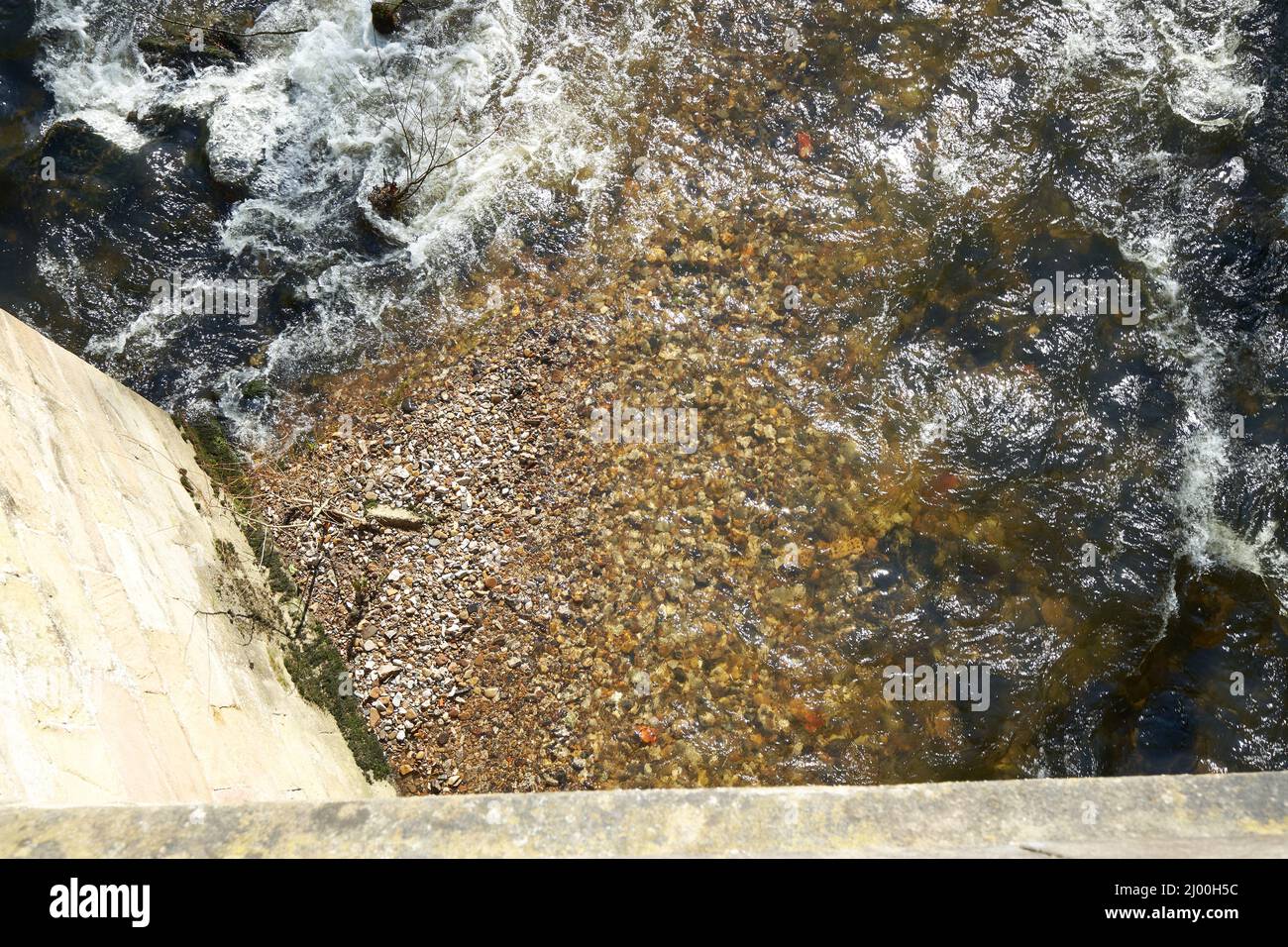 Pebbles in shallow choppy river water Stock Photo - Alamy