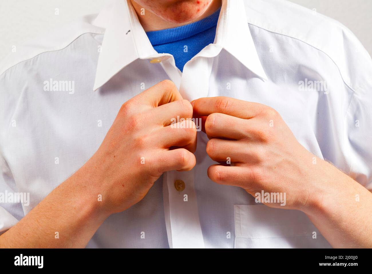 buttoning a fresh, white shirt, on plain white background Stock Photo ...
