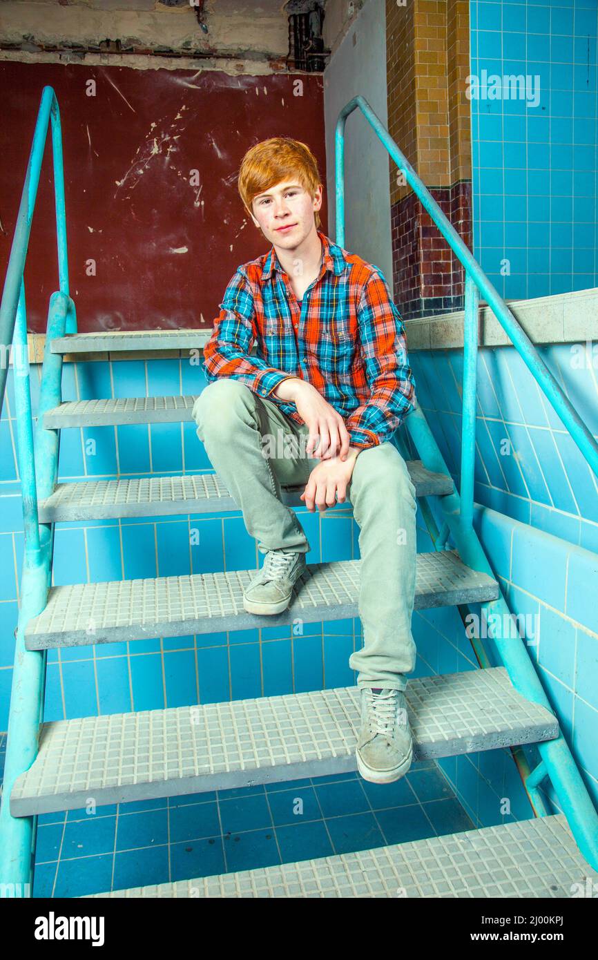 boy sitting on the stairs of an old waterless pool Stock Photo - Alamy