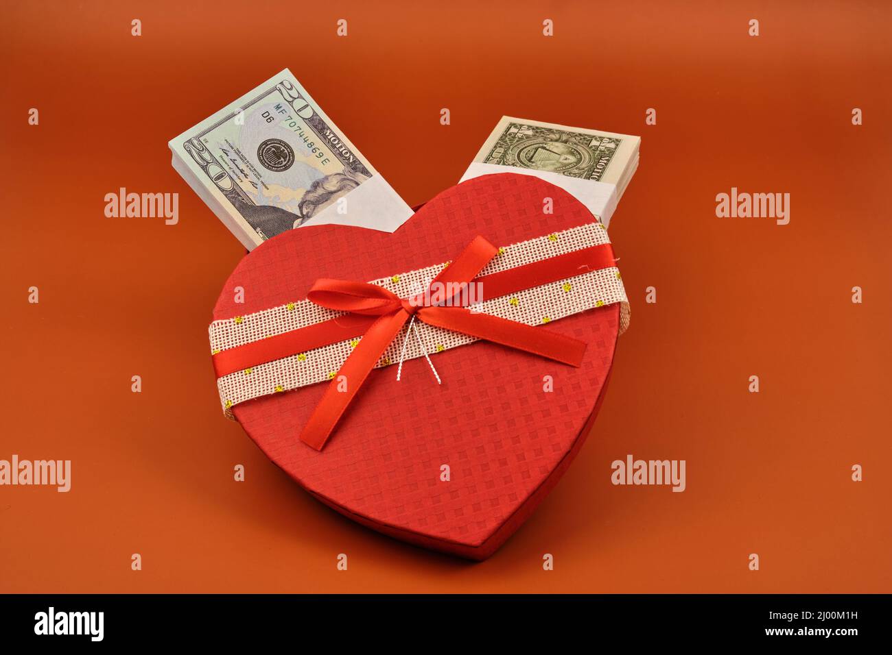 Gift in the shape of a heart filled with dollars that come out of the ...