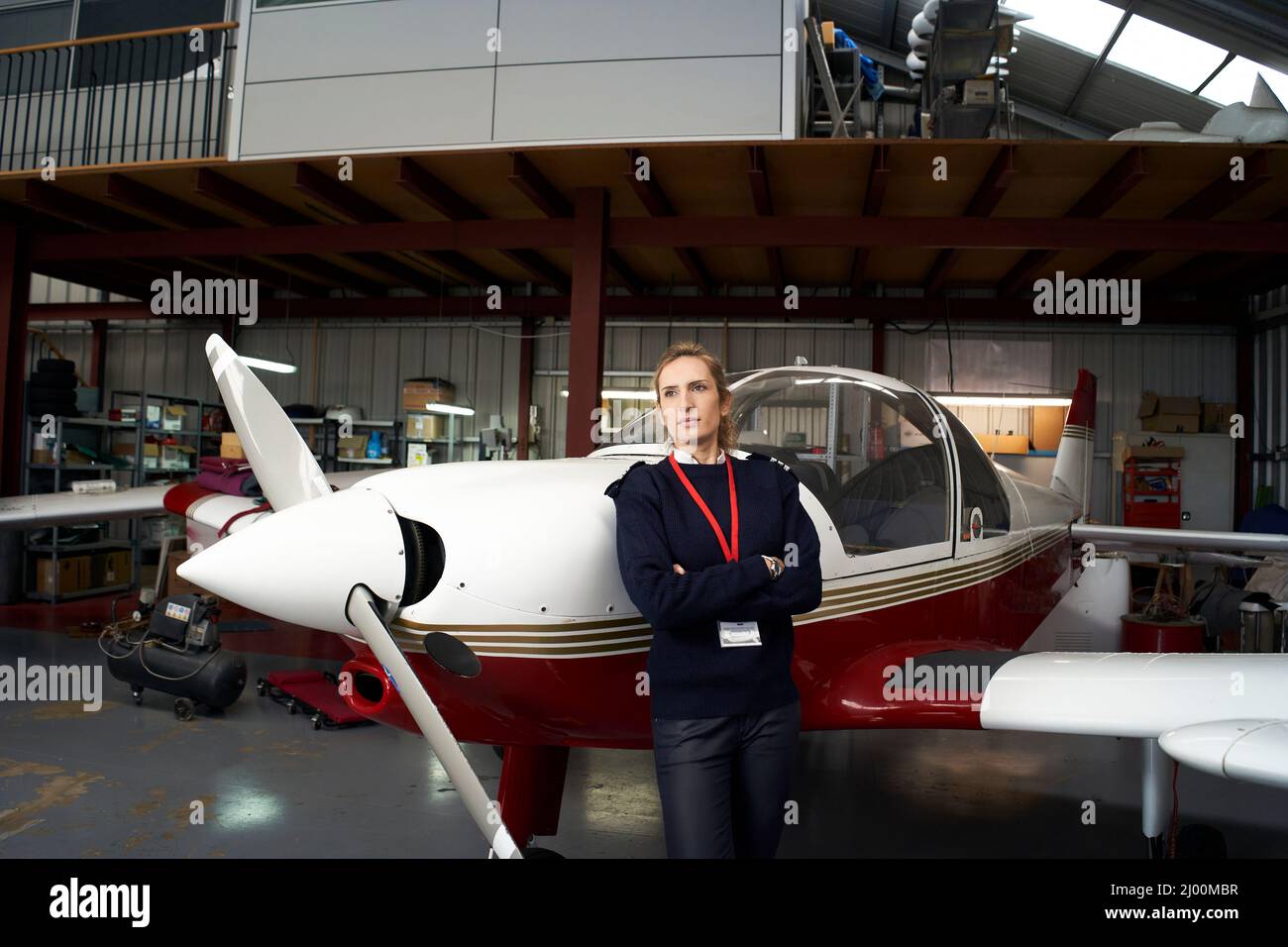 Young female pilot posing in front of her plane inside the hangar Stock ...