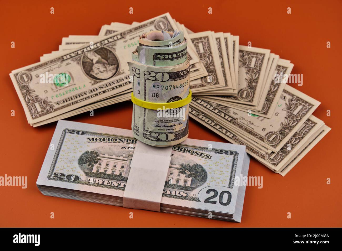 Rolled up bundle of bills with many bills on an orange background Stock ...