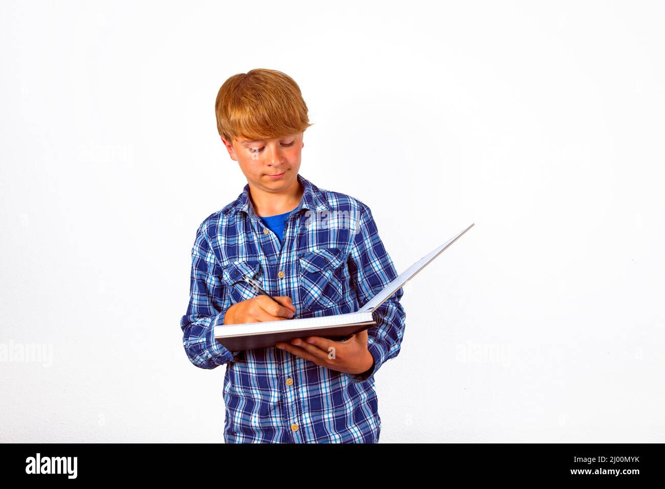 happy smart boy is writing into a book Stock Photo - Alamy