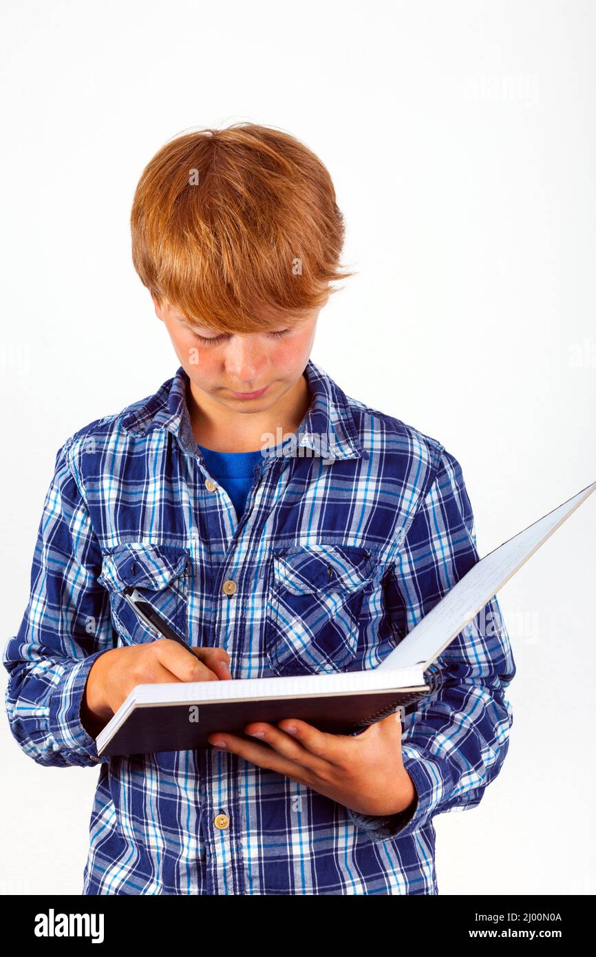 happy smart boy is writing into a book Stock Photo - Alamy