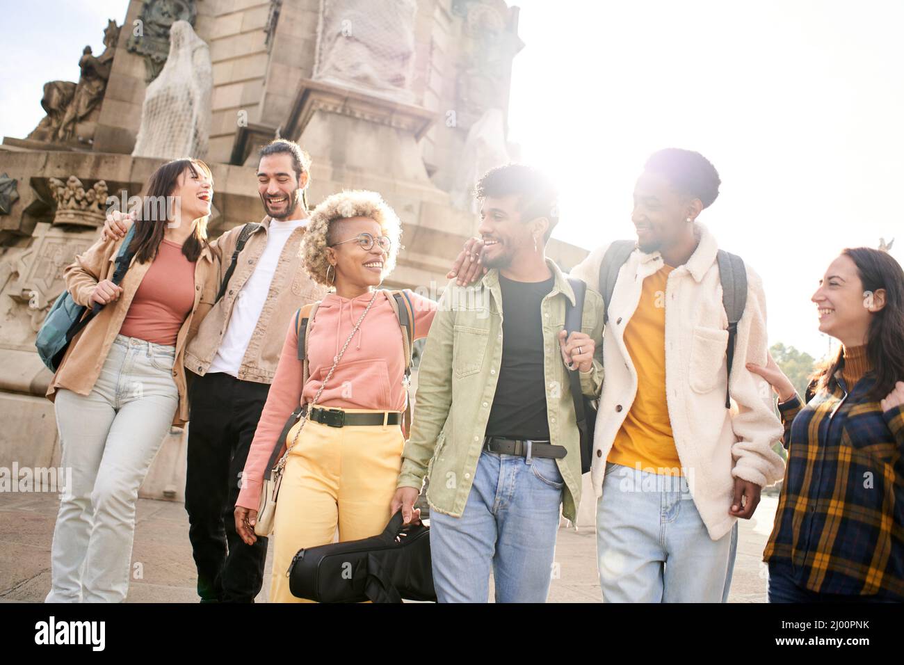 College students walking together outdoors. Group of young friends in ...
