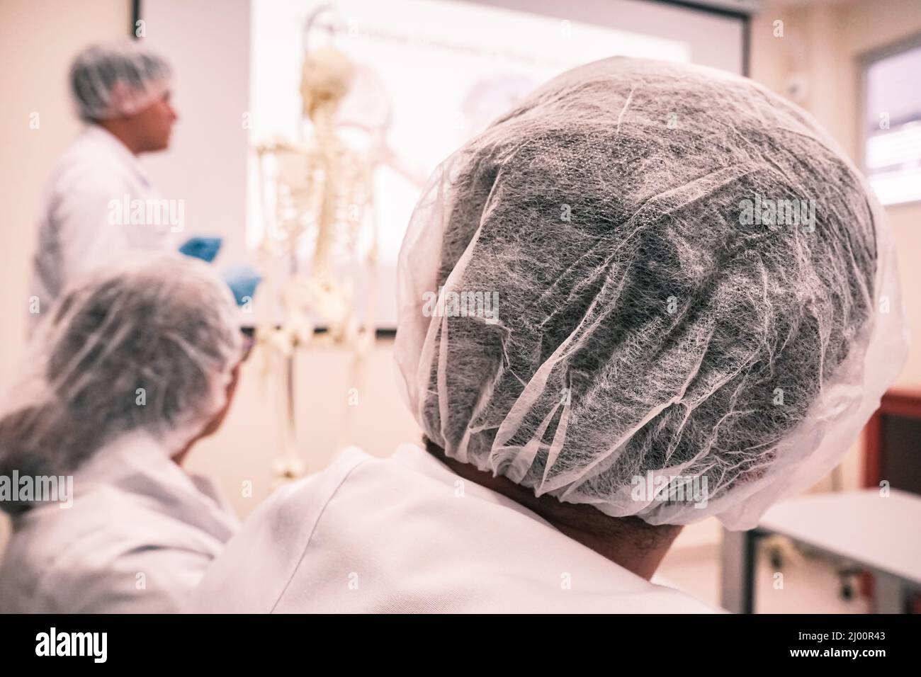 Unrecognizable medical students and professor dressed as a doctor ...