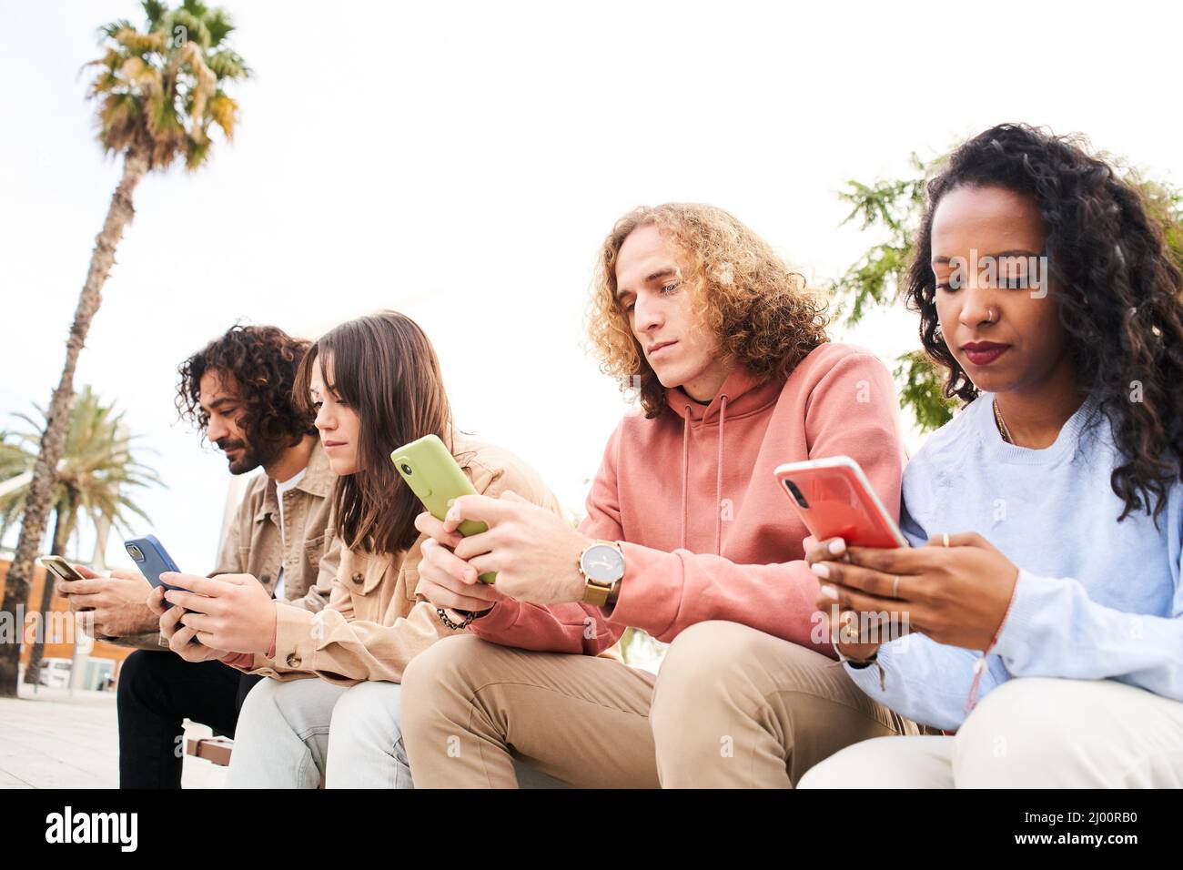 Group of people using phone with serious face. Friends focused on their ...