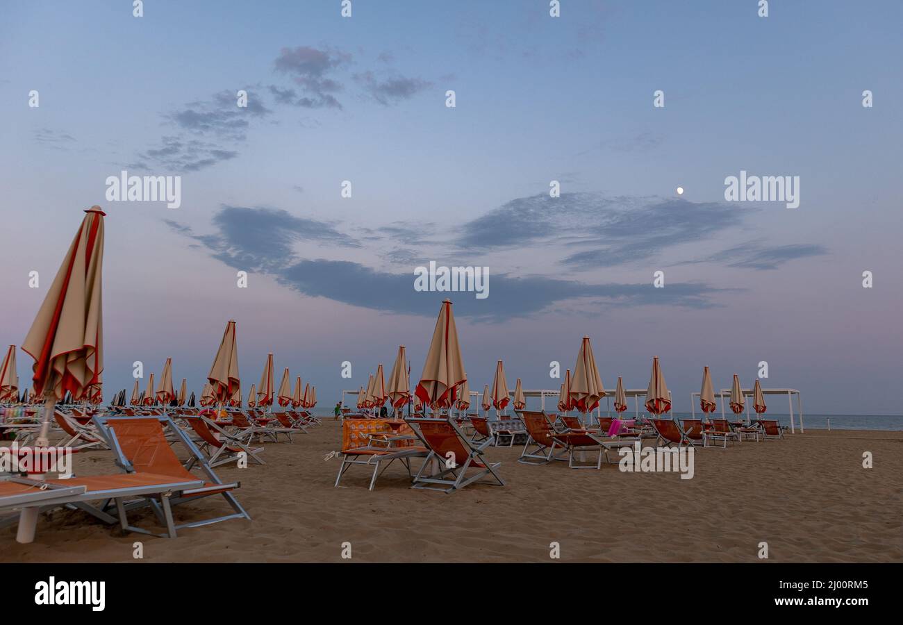 Scenic view of the sandy beach at the sunset with the deck chairs and ...