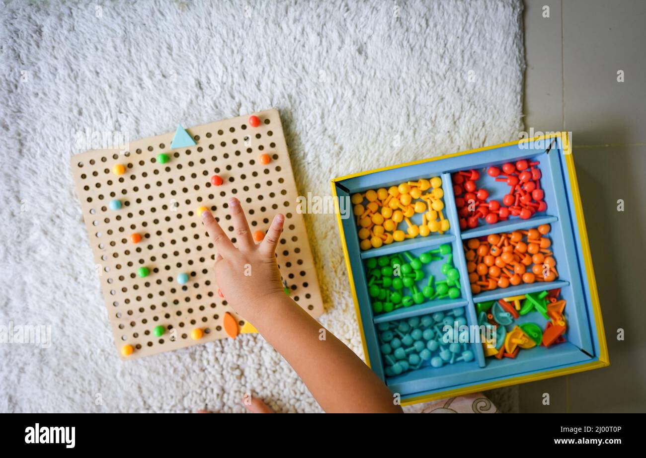 Top view of a child's hand playing an educational game sorting colors ...