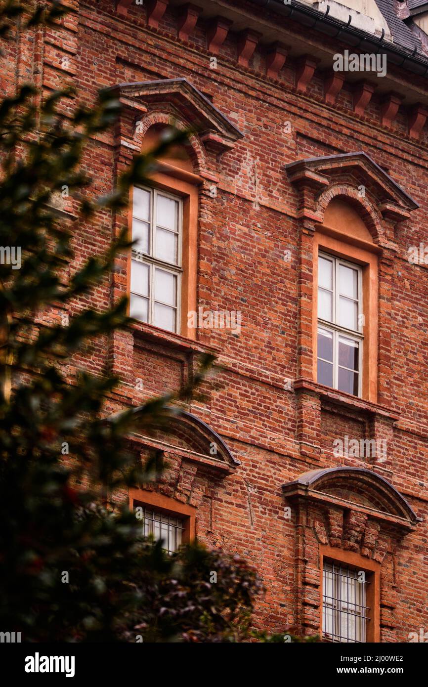 Vertical shot of and old european brick house behind the tree in ...