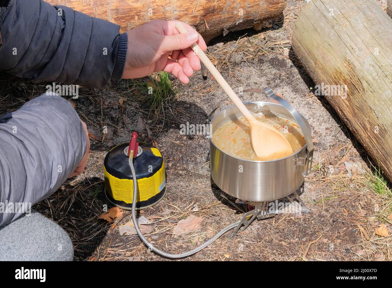Camping food making. Traveler foods for outdoor activities. Soup in pot ...