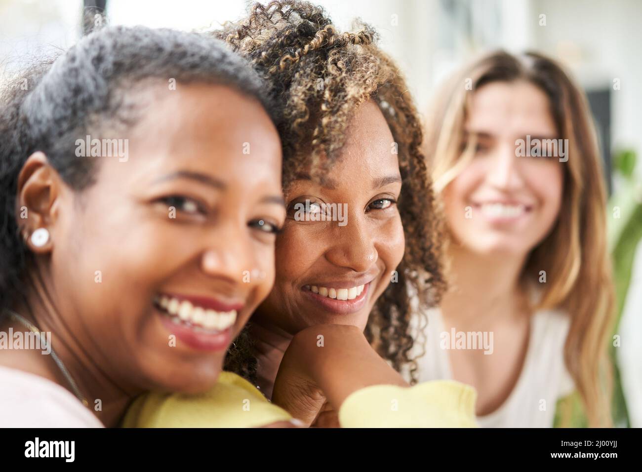 Female face of Three young multiracial only women looking camera. Happy ...