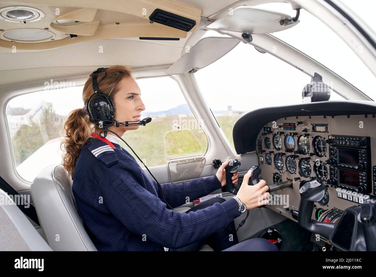Side view of a female pilot in the cockpit of an airplane Stock Photo ...