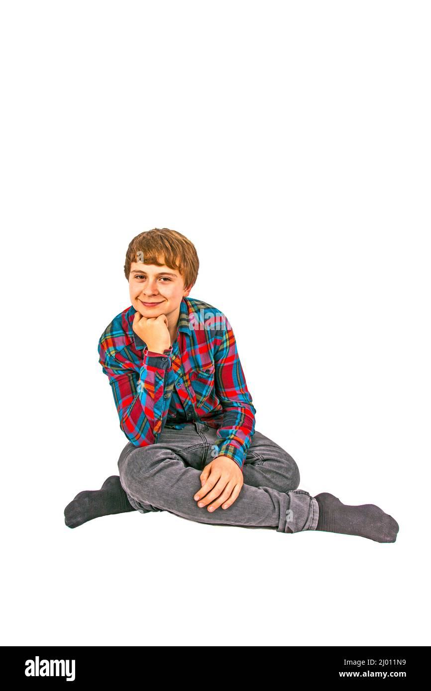 happy boy in studio looking confident and sitting on the floor Stock ...