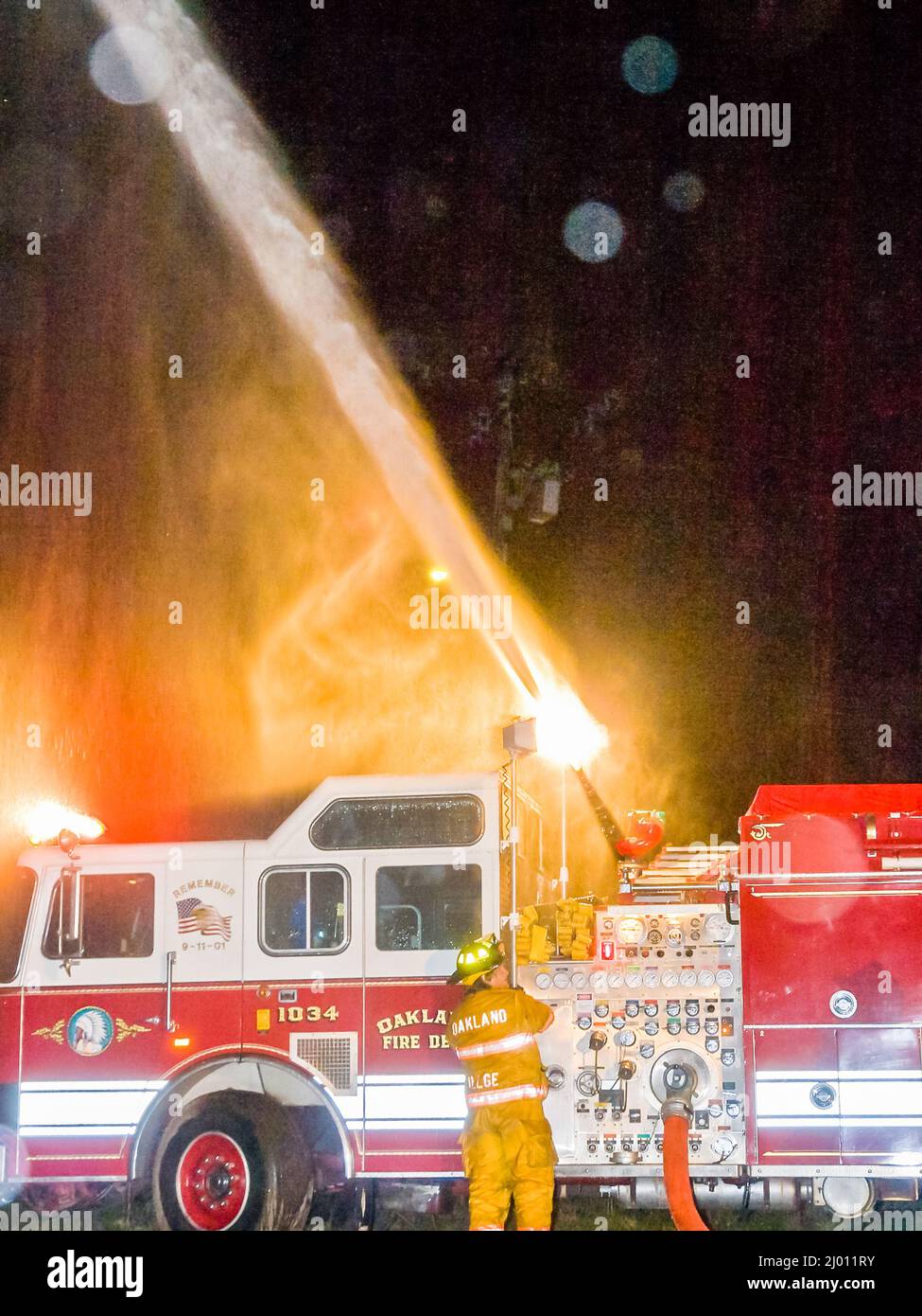 Firefighters in action at night with truck and water cannon Stock Photo ...
