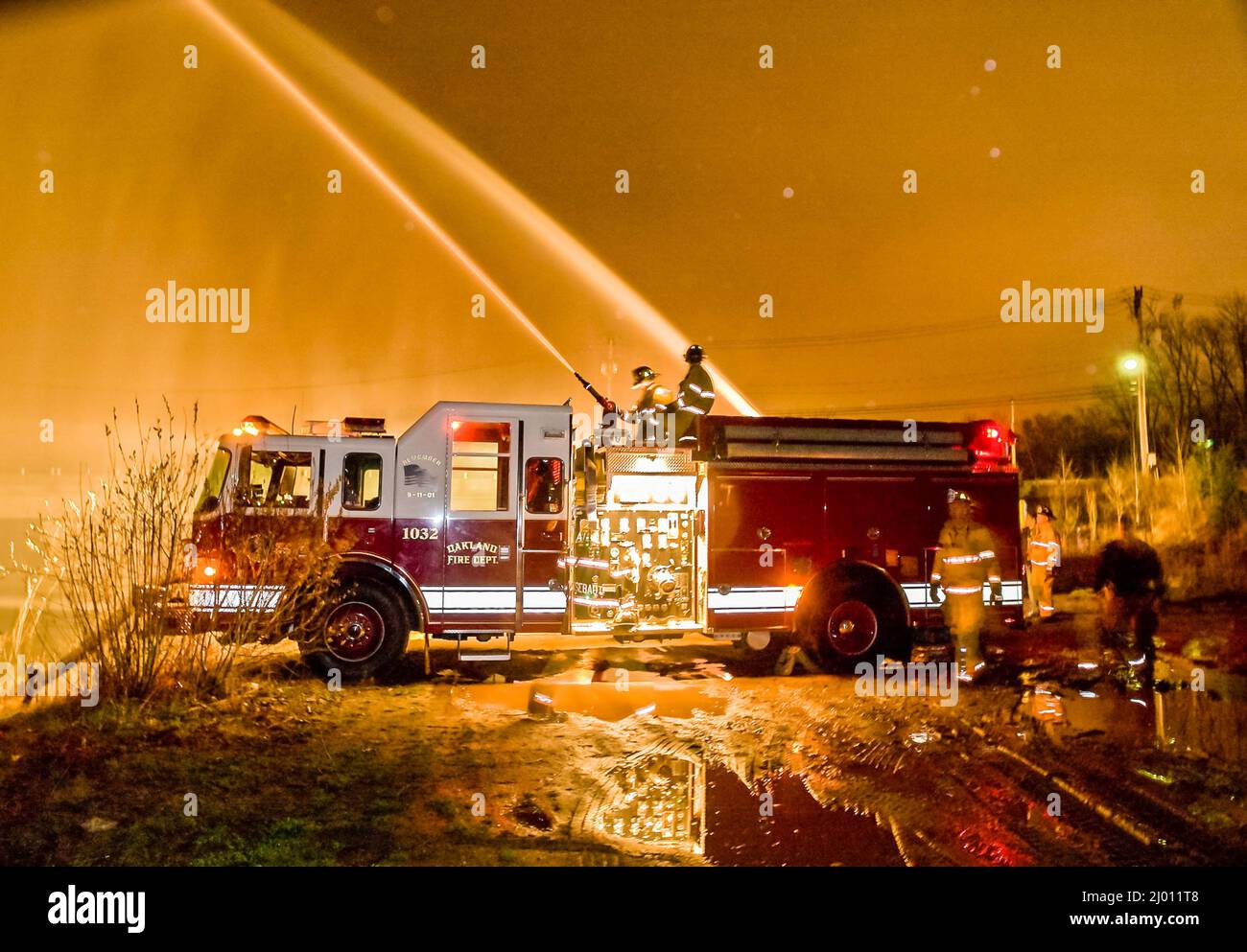 Firefighters in action at night with truck and water cannon Stock Photo ...