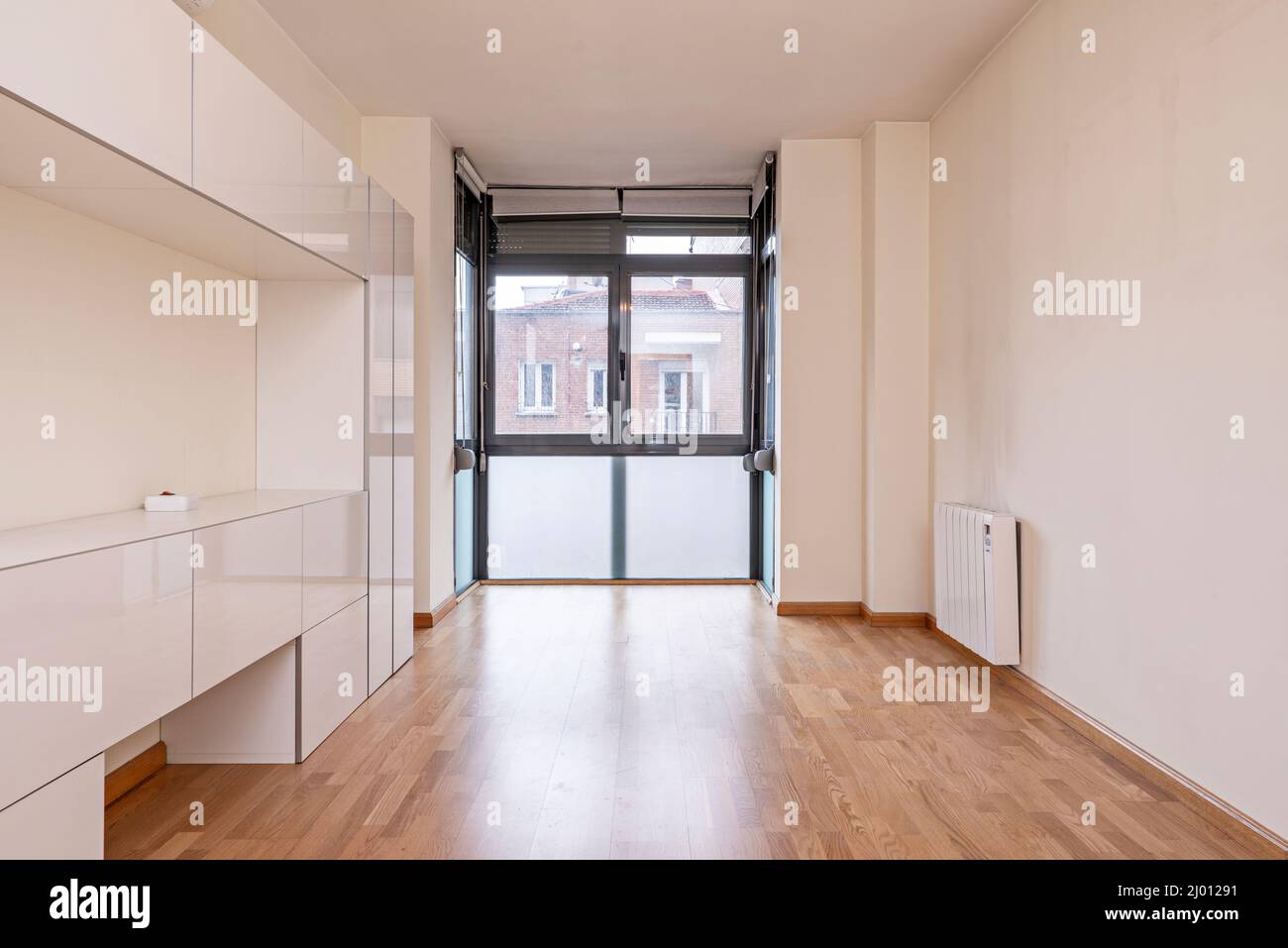 Empty living room with white mural cabinet and window in the background ...