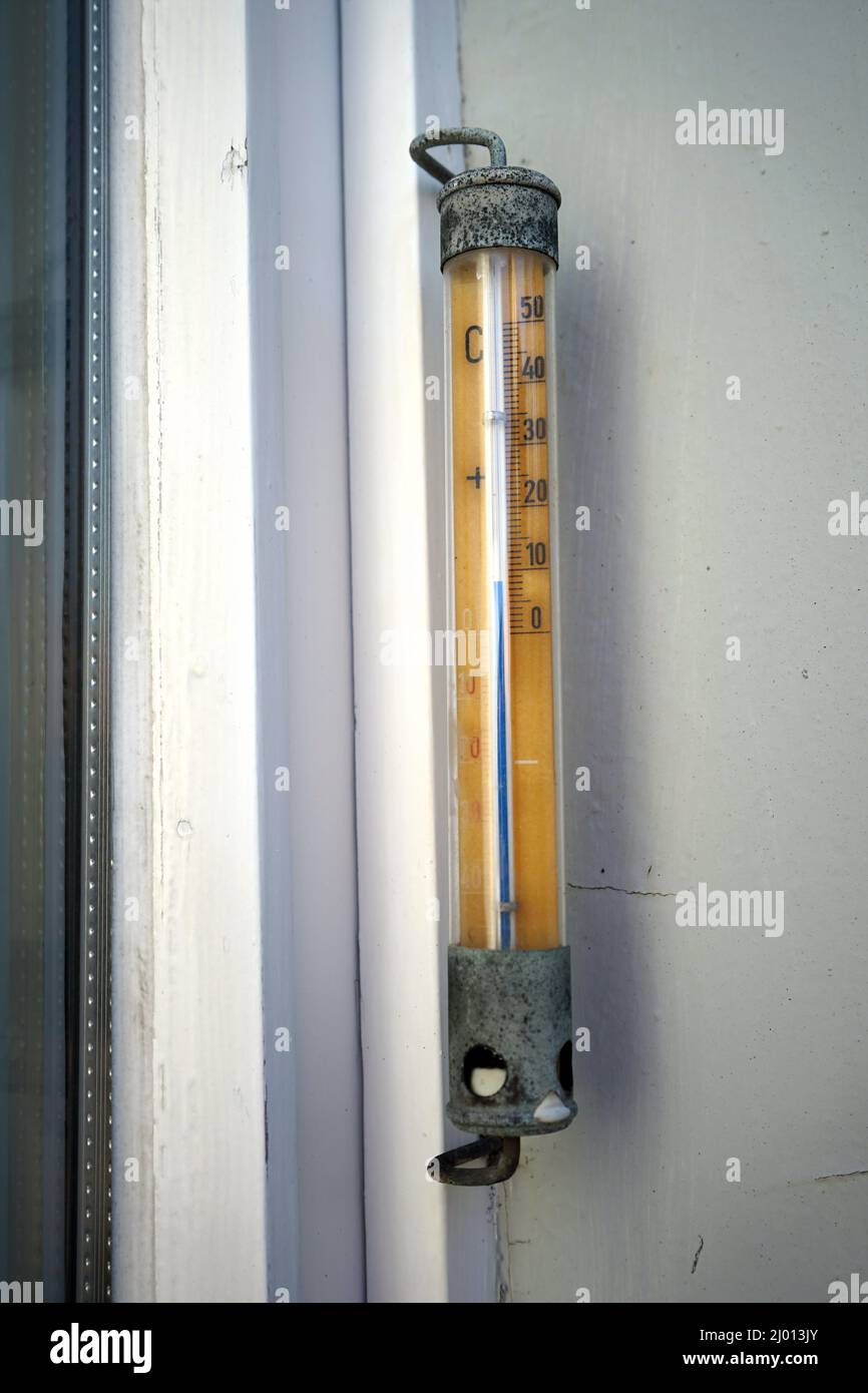 Vertical shot of a thermometer showing the a temperature on a white ...
