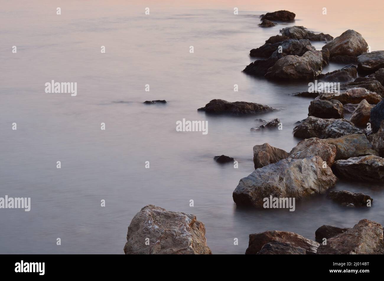 Beach with big rocks and the calm water Stock Photo - Alamy