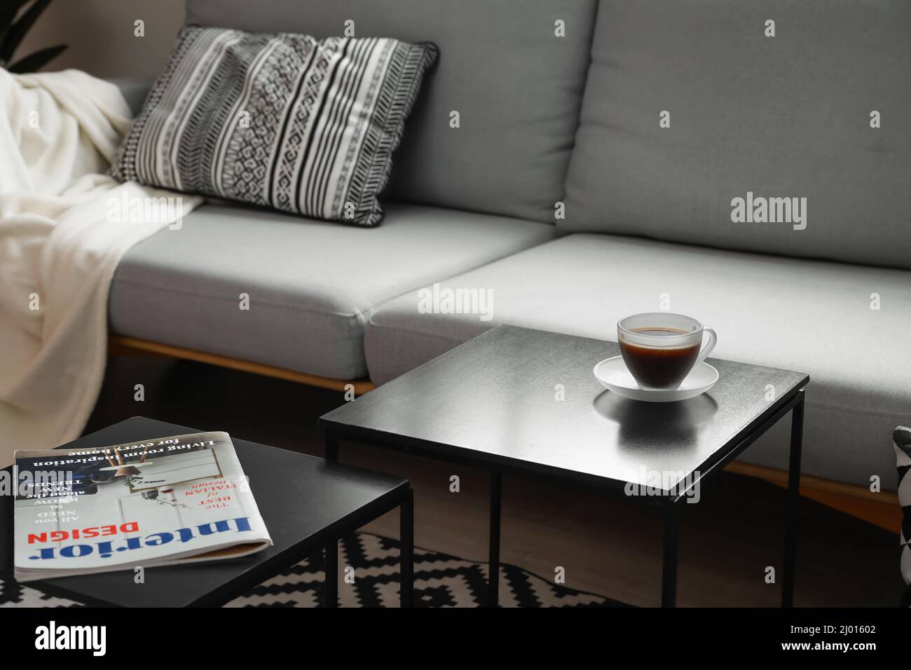 Cup of coffee and magazine on tables in room Stock Photo - Alamy