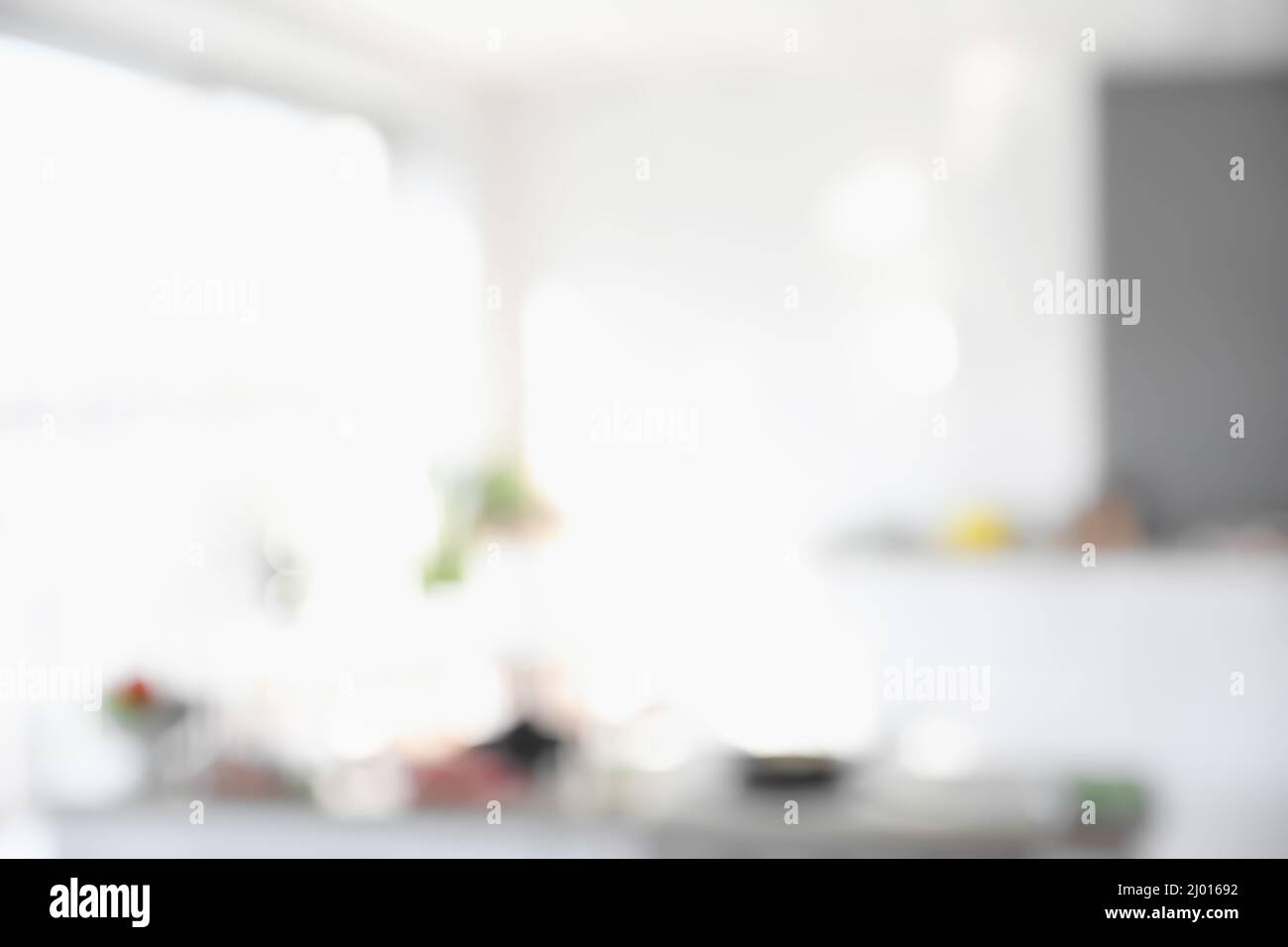 Blurred view of light kitchen with counters and window Stock Photo - Alamy