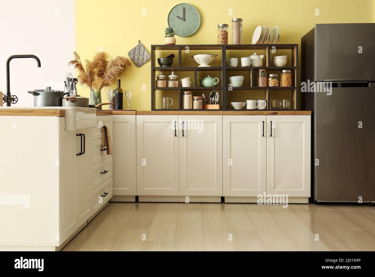 Interior of modern kitchen with white counters, shelving unit and ...
