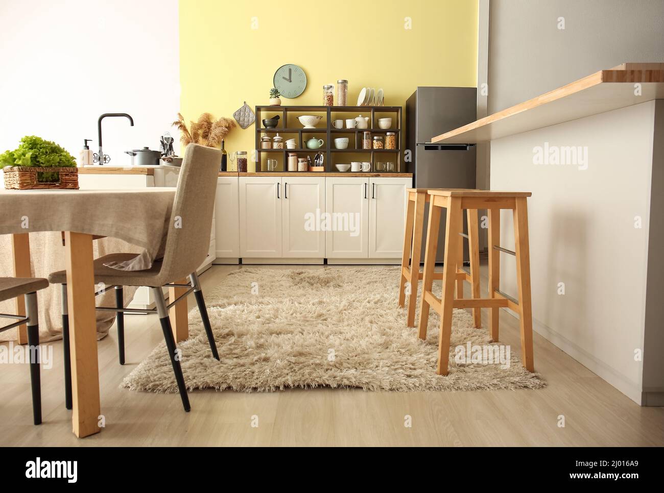 Interior of stylish kitchen with white counters, shelving unit and ...