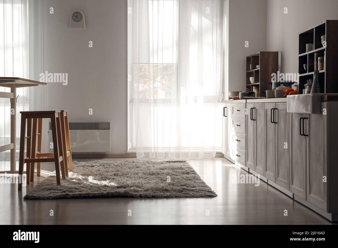 Interior of modern kitchen with white counters, shelving units and ...