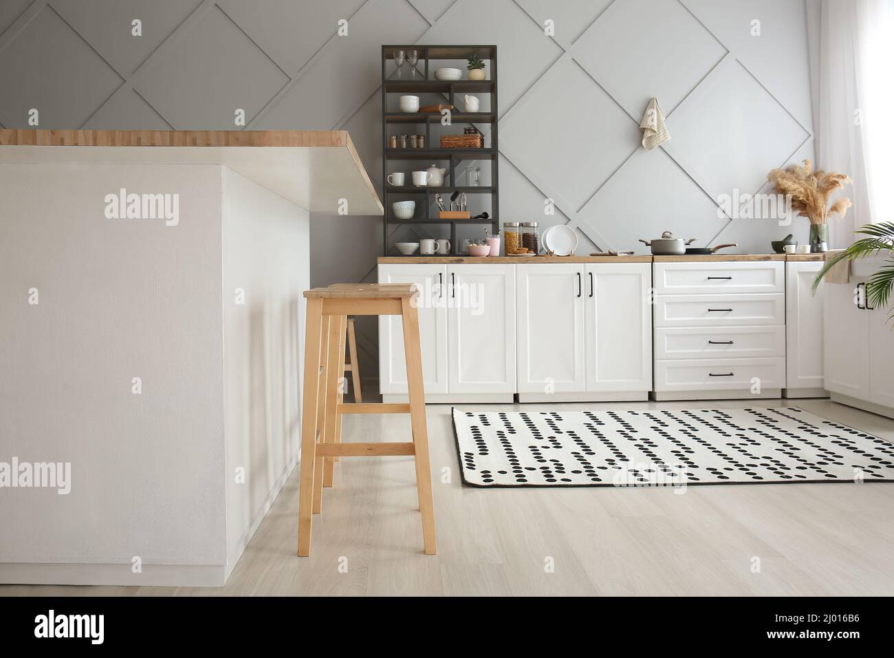 Interior of light kitchen with white counters, shelving unit and food ...