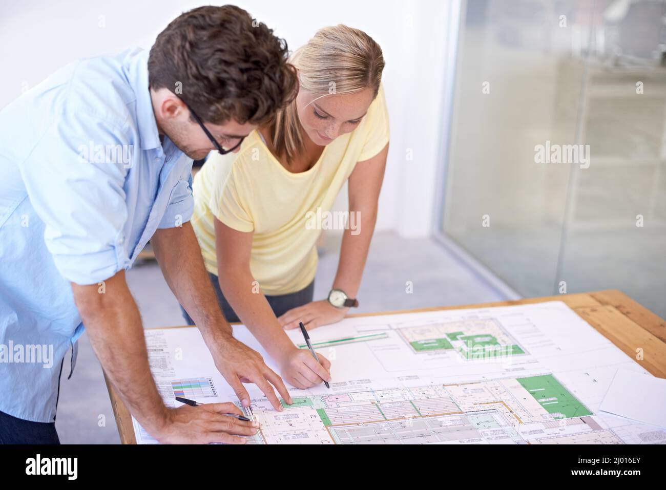 Planning out the fine details. Two architects discussing elements of an ...
