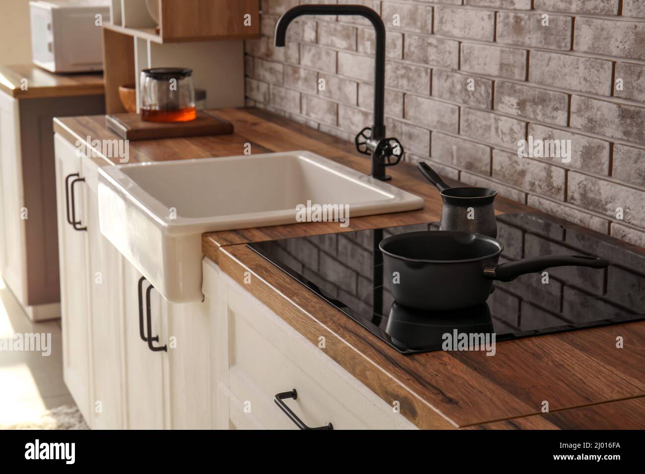 Cooking pot and cezve on electric stove in modern kitchen Stock Photo ...