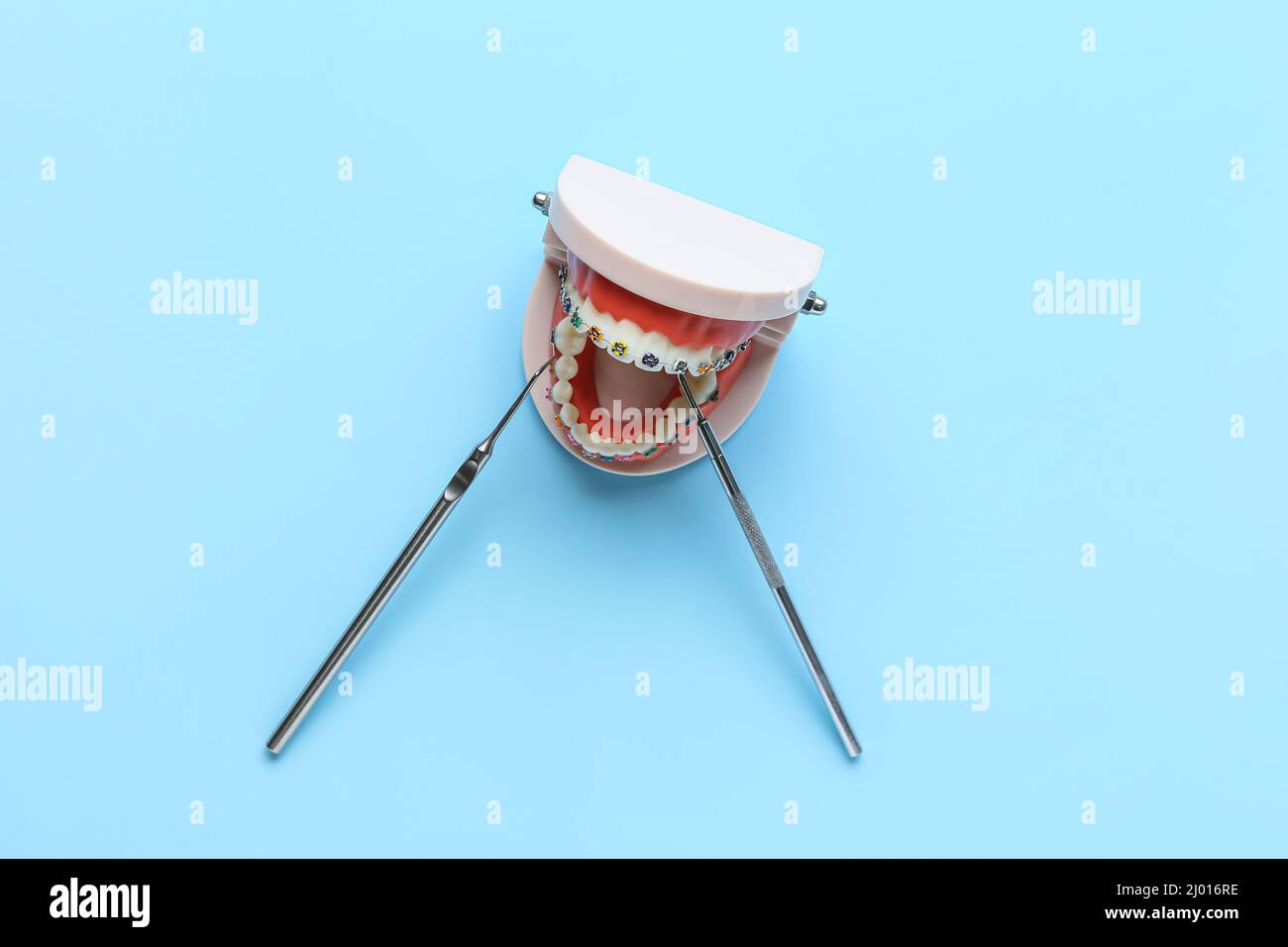 Model of jaw with dental braces and dentist tools on blue background ...