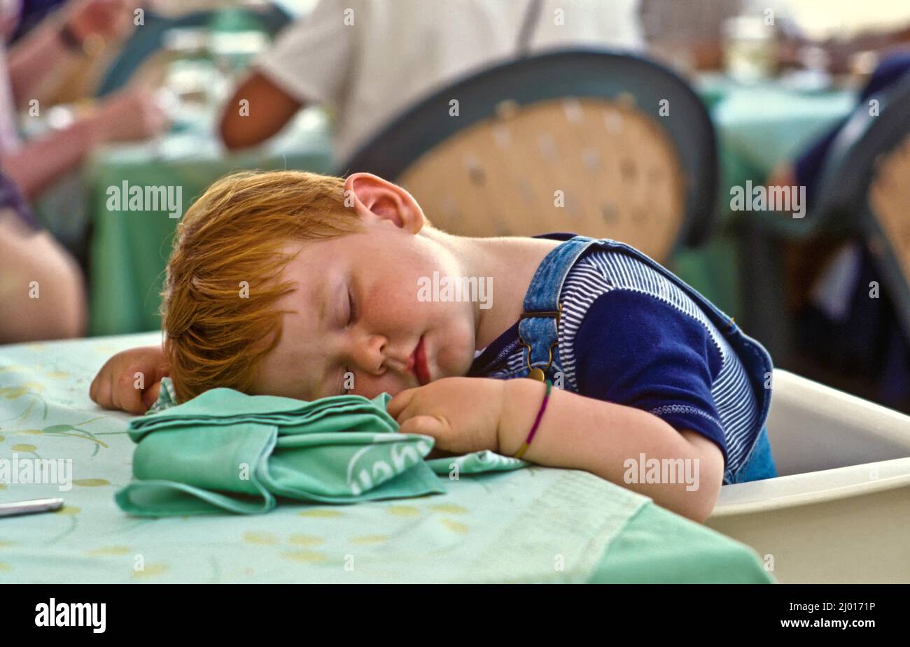 young boy falling asleep on the dinner table Stock Photo - Alamy