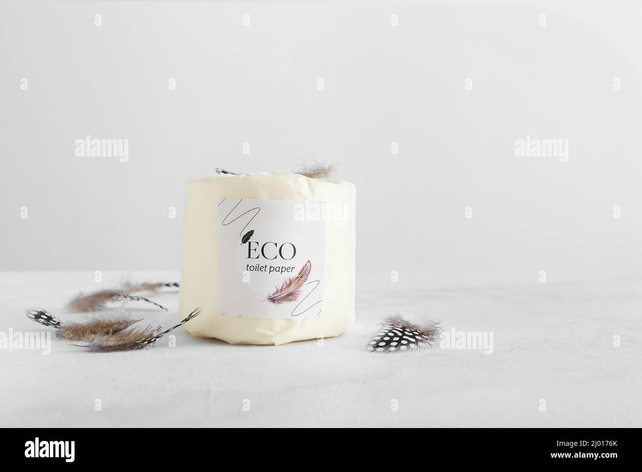 Toilet paper roll and feathers on light background Stock Photo - Alamy