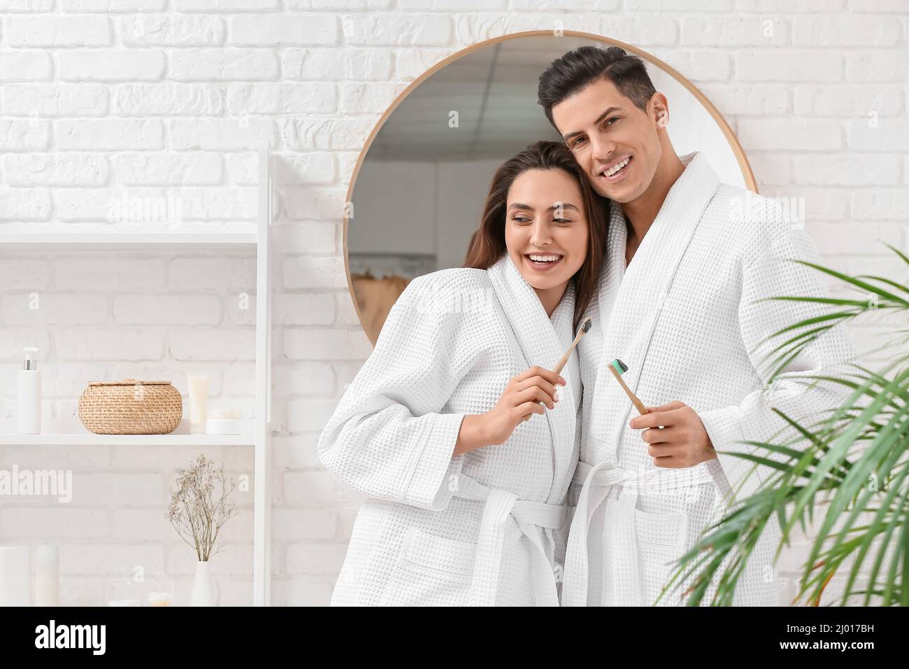 Young couple brushing teeth with activated charcoal tooth paste in ...