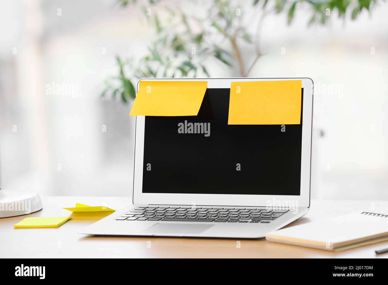Laptop with sticky notes and notebook on table near window Stock Photo ...