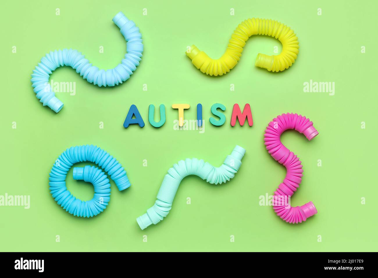 Word AUTISM with Pop Tubes on green background Stock Photo - Alamy