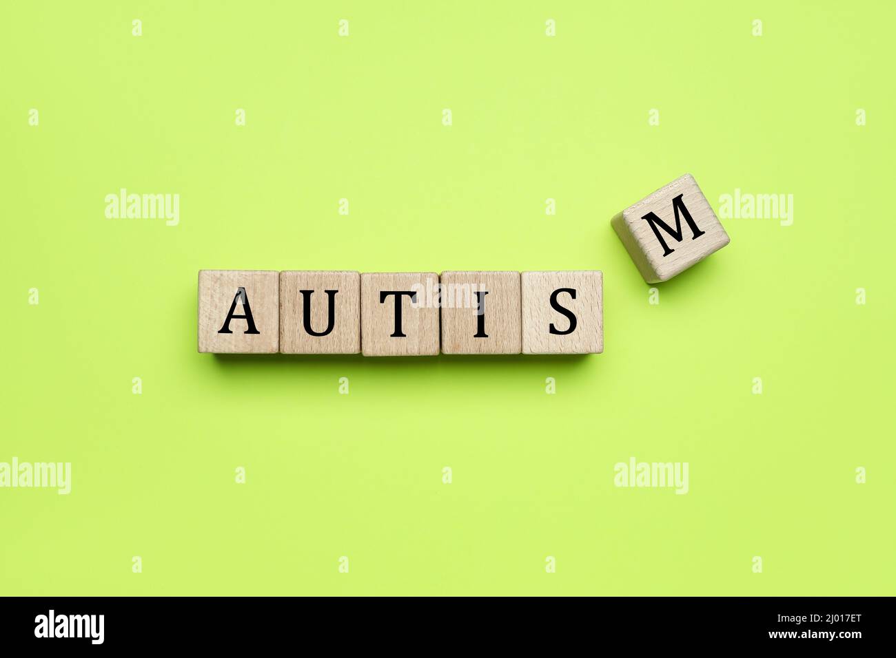 Wooden cubes with word AUTISM on green background Stock Photo - Alamy