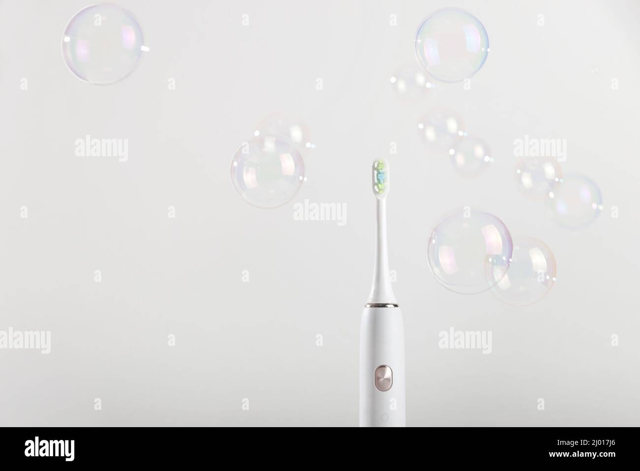 Electronic toothbrush among bubbles on white background Stock Photo - Alamy